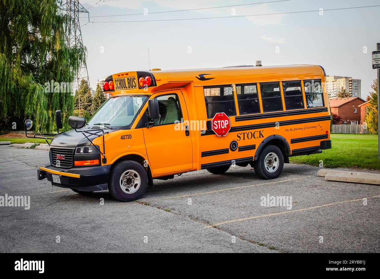 yellow school bus parked at a school parking lot Stock Photo - Alamy