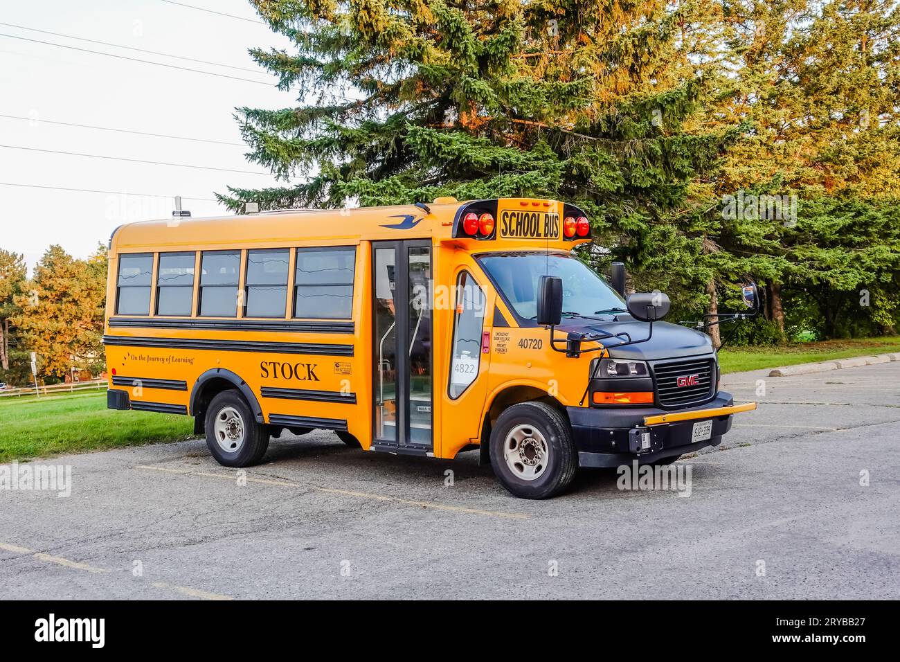 yellow school bus parked at a school parking lot Stock Photo - Alamy