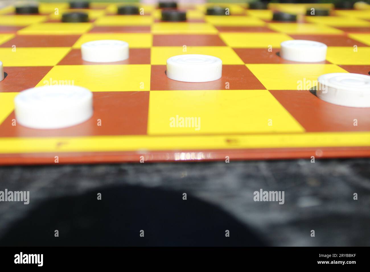 A game of checkers. checkers on a yellow brown chessboard. Street games ...
