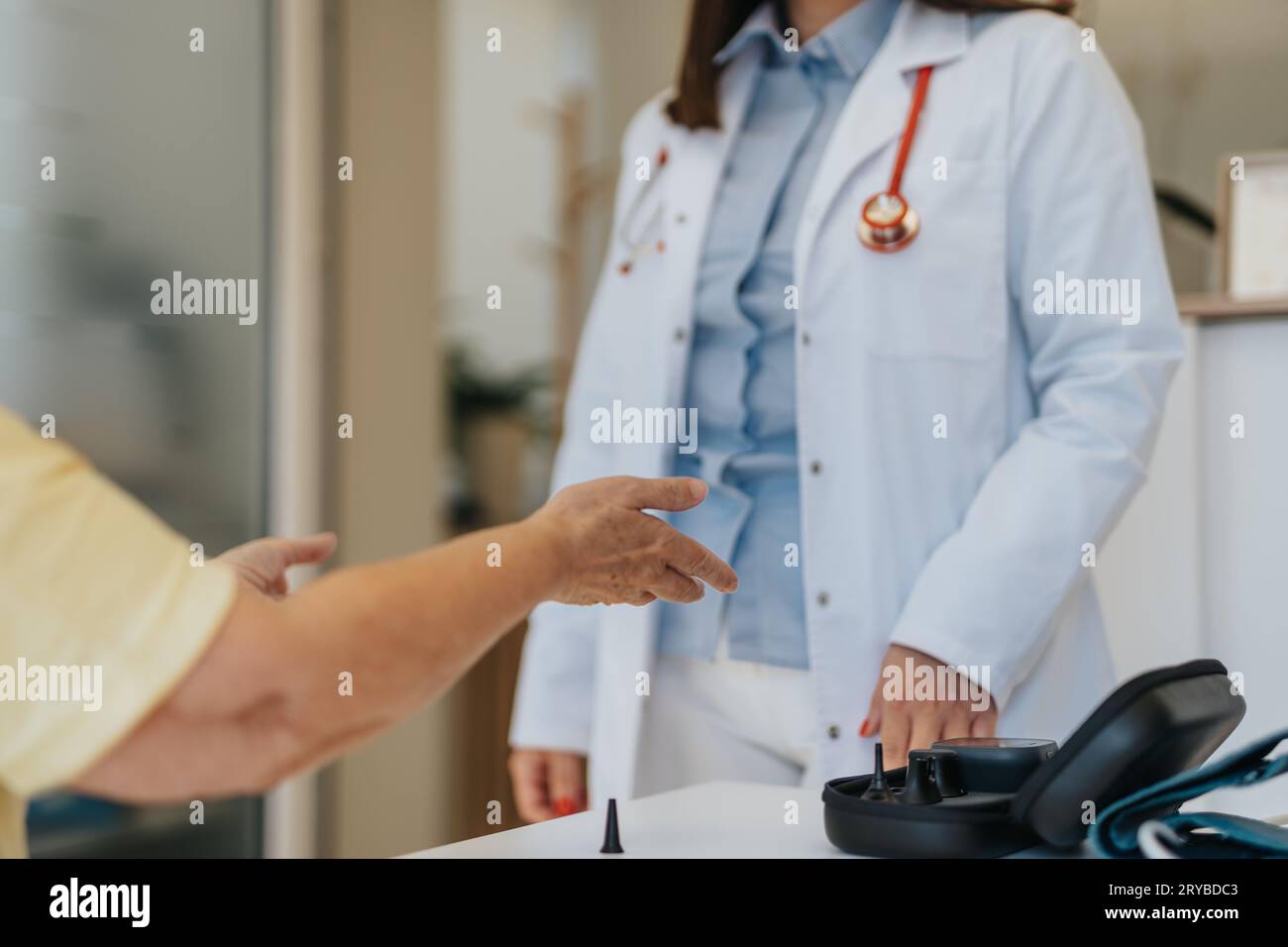 Elderly woman explaining her health problems and pain to her doctor ...