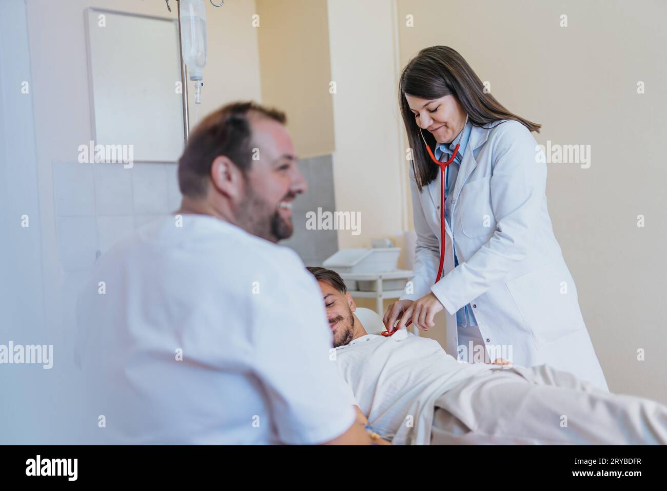 A doctor provides medical care and infusion therapy to a patient in a hospital room. Expert ...