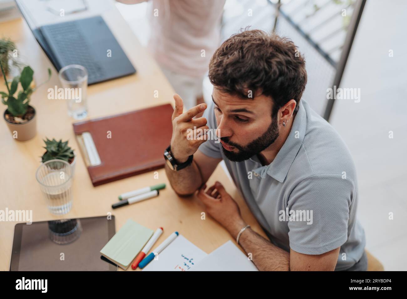 Good looking male employee gesturing with hand while explaining ...