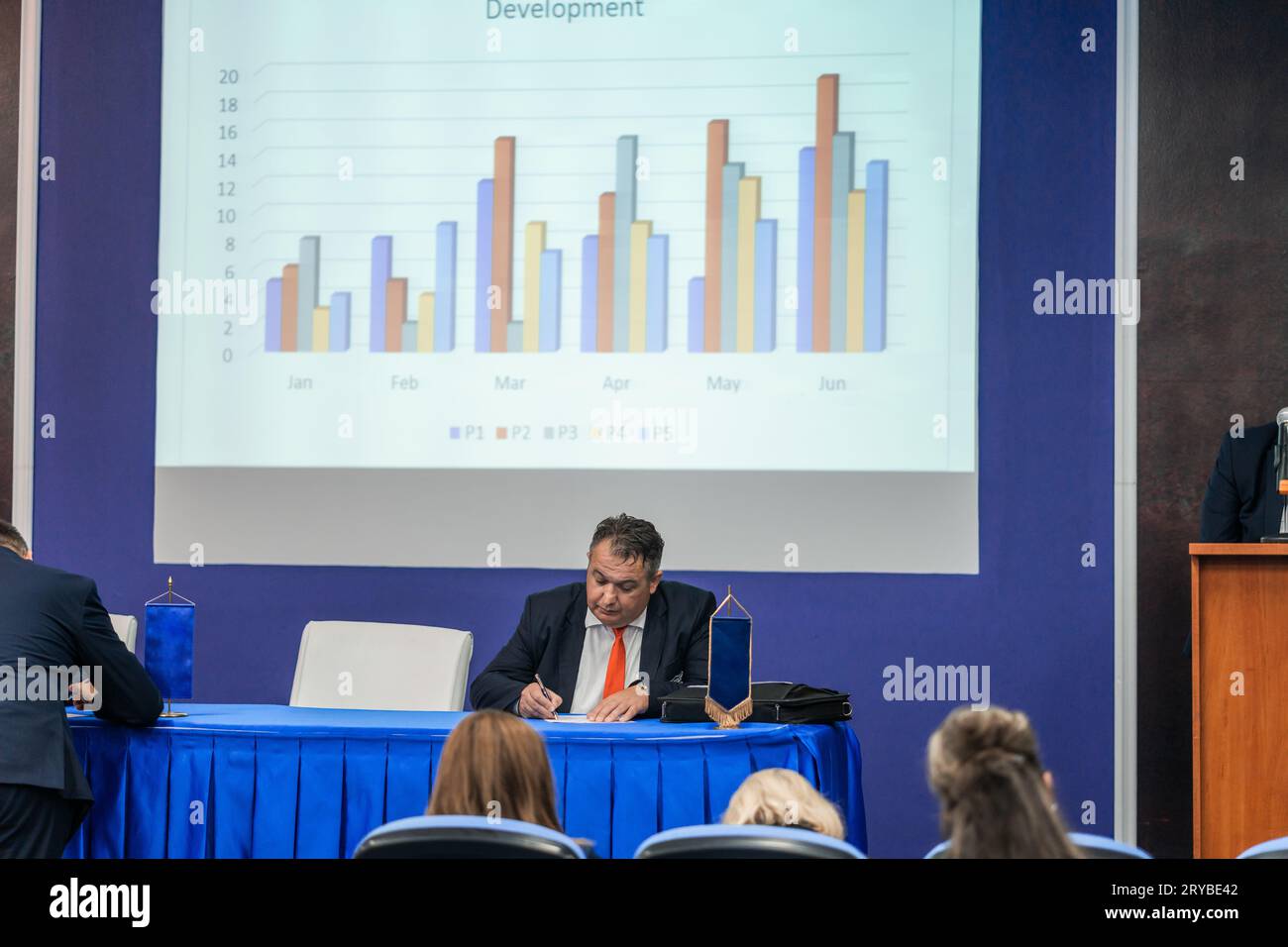 A diverse group of business professionals attending a seminar in a ...