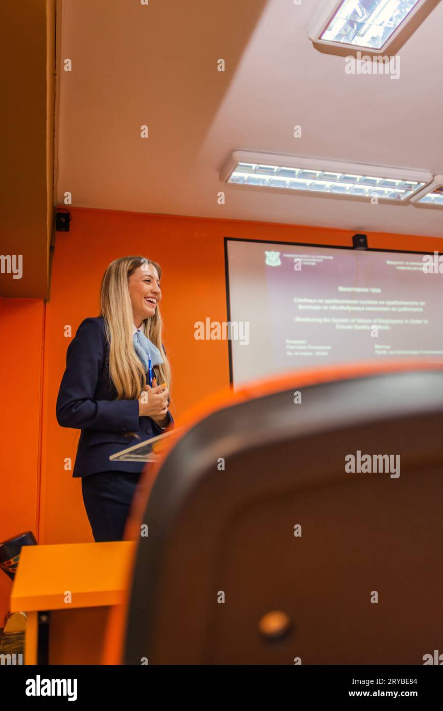 Young university student giving a speech on the podium defending her ...