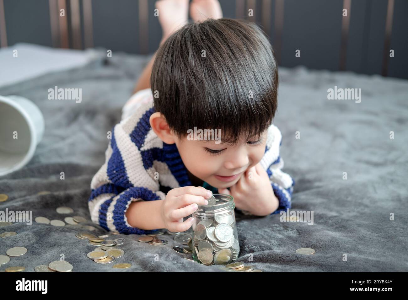 Asian boy happily counting coins to save money Stock Photo - Alamy