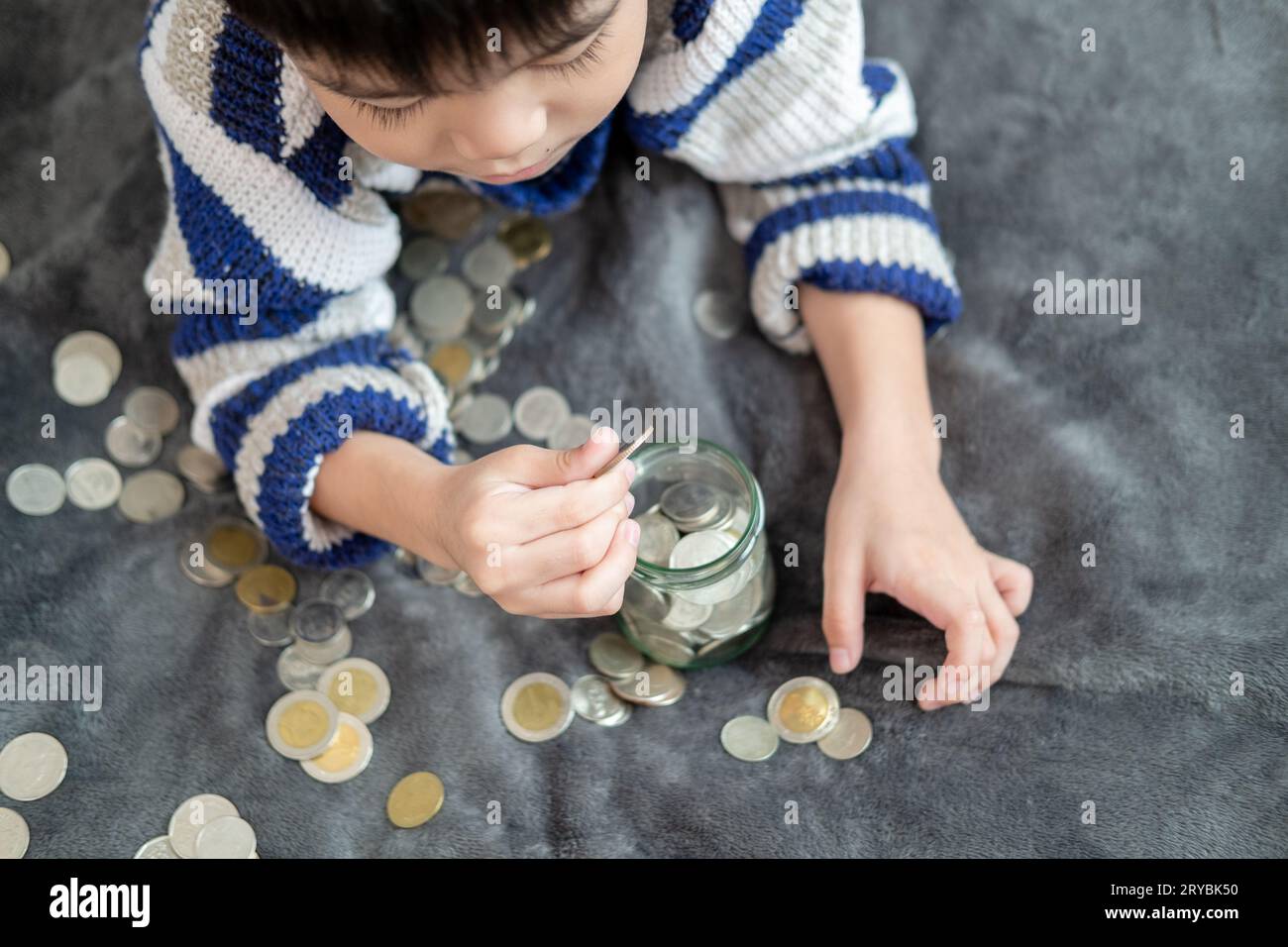 Asian boy happily counting coins to save money Stock Photo - Alamy