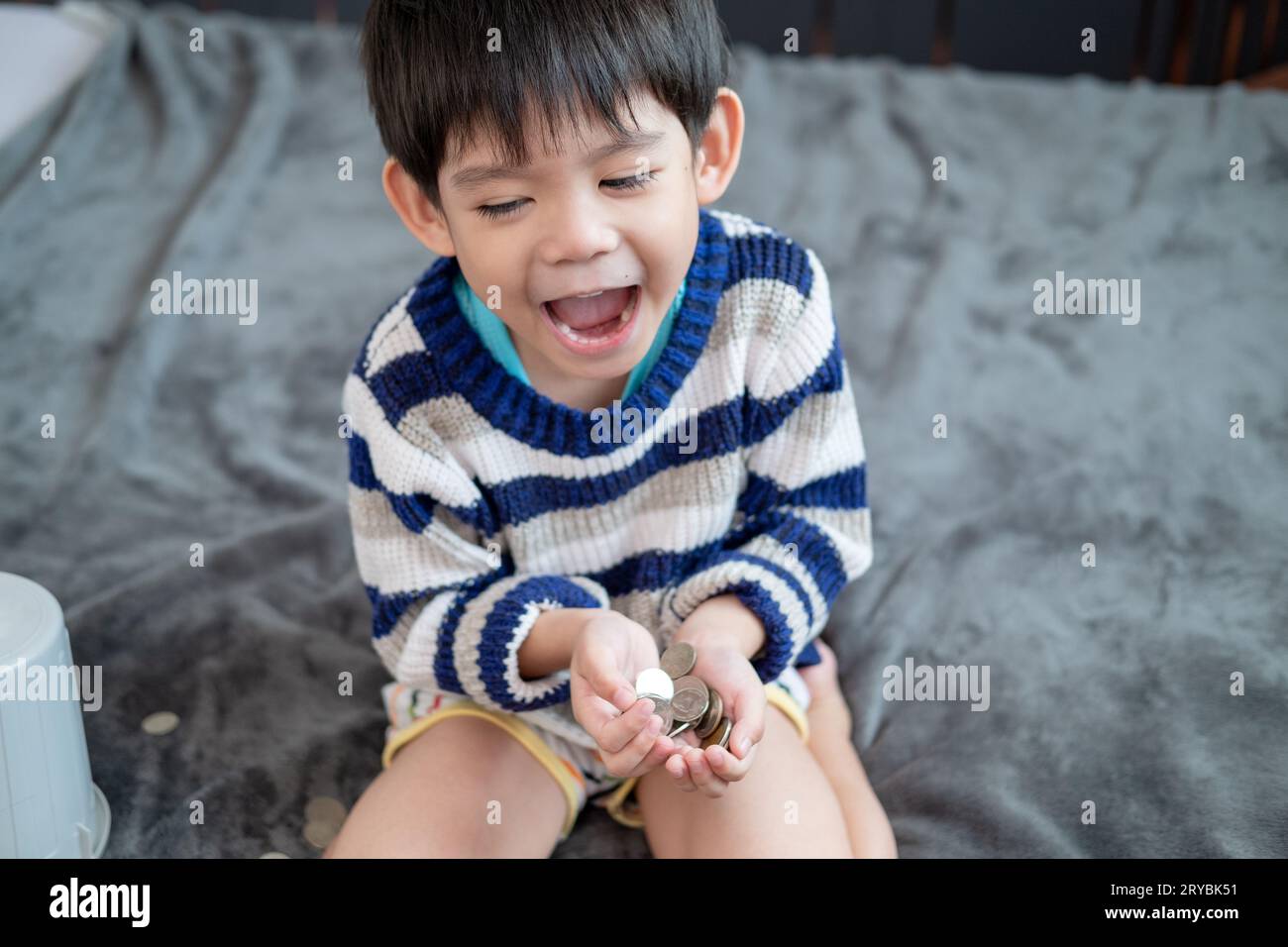 Asian boy happily counting coins to save money Stock Photo - Alamy