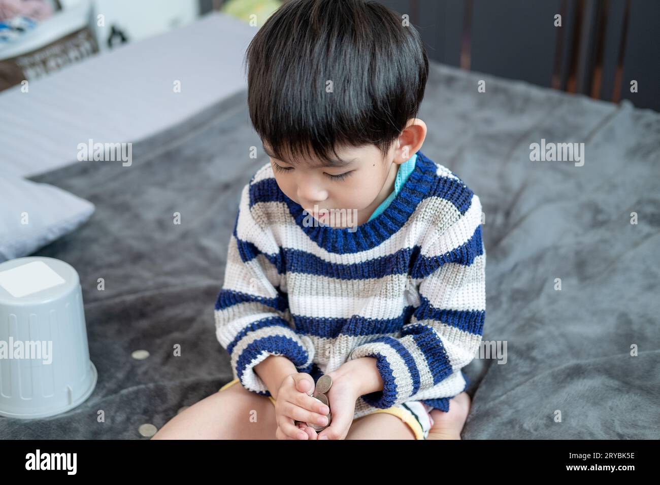 Asian boy happily counting coins to save money Stock Photo - Alamy