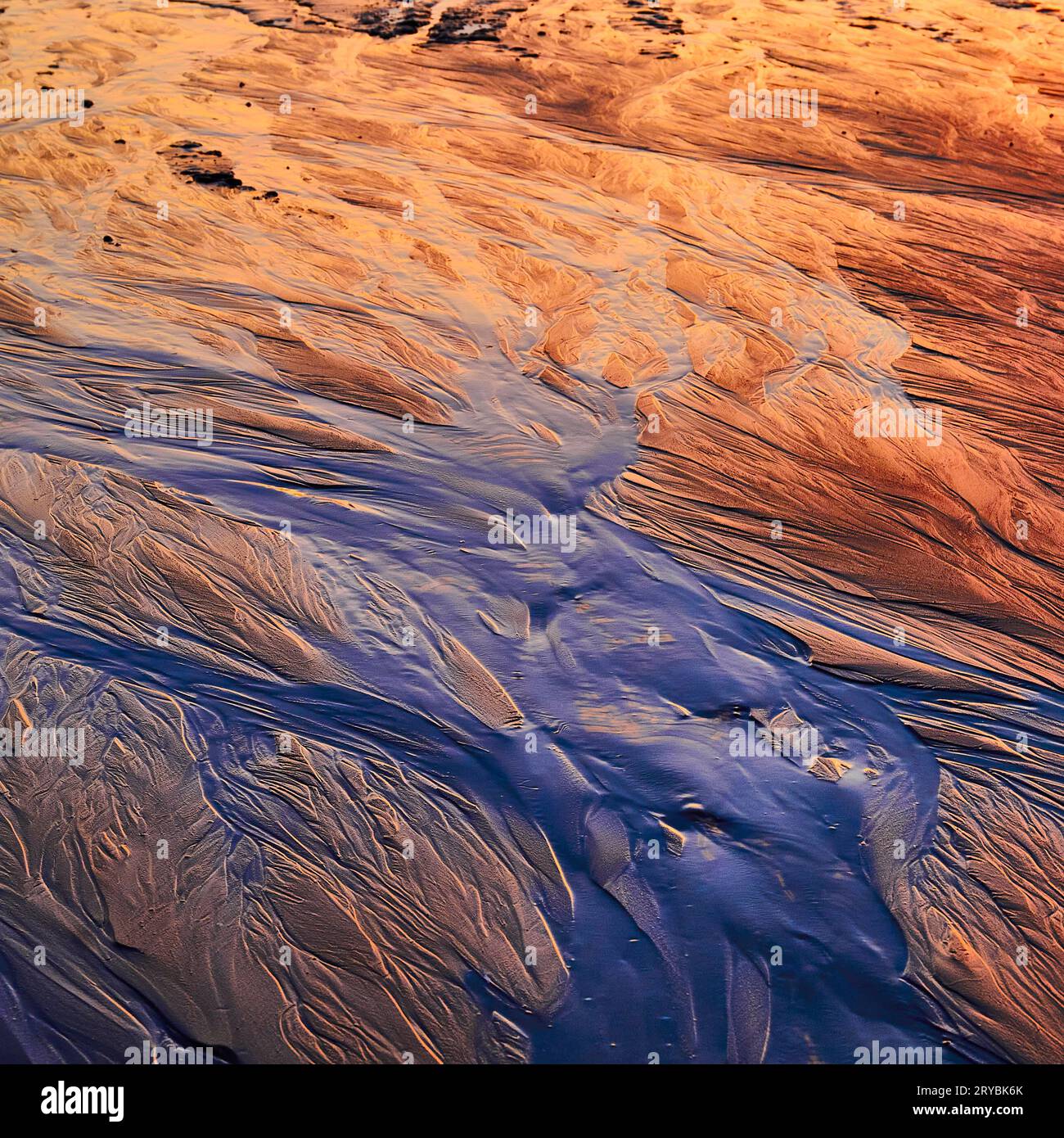 Small streams of blue water over red sand at dusk Stock Photo - Alamy