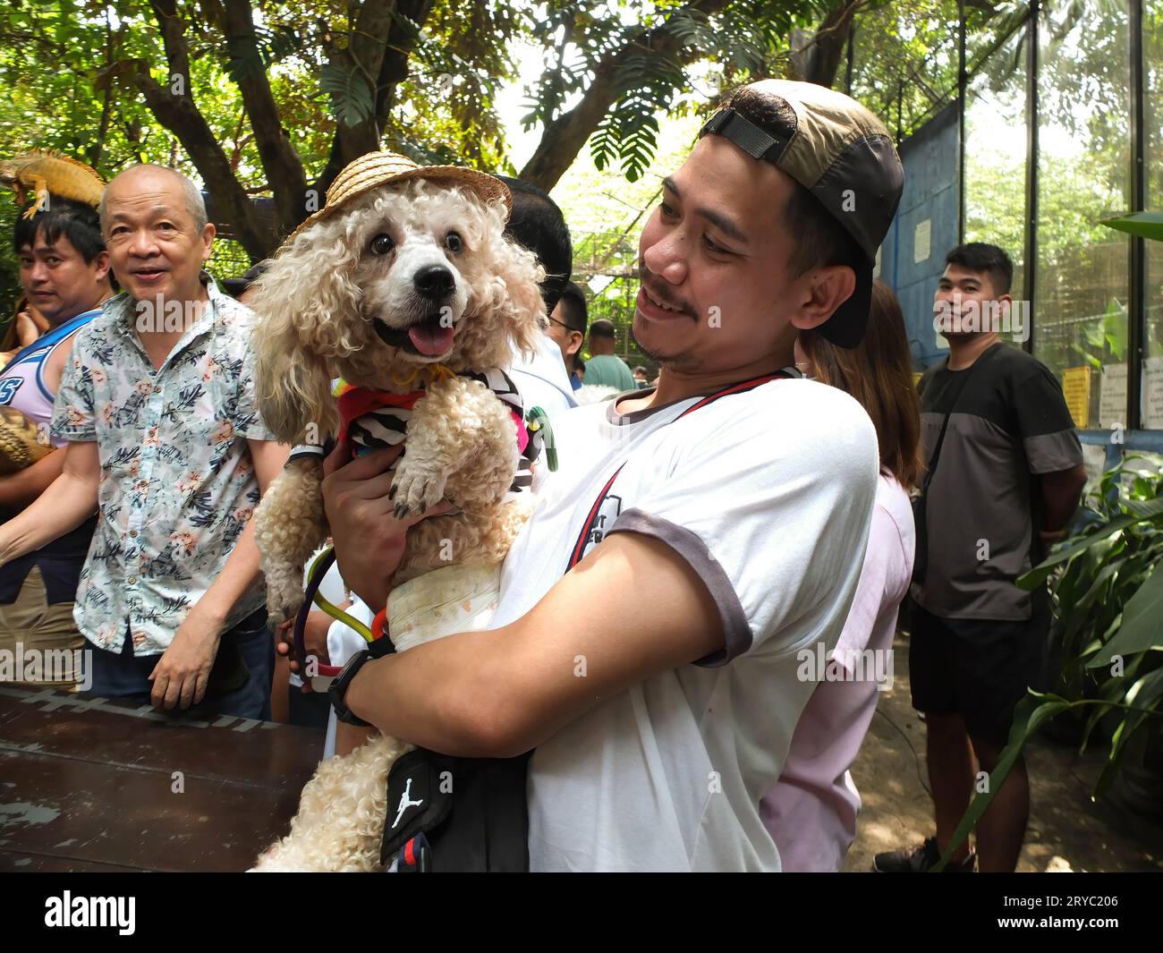 A visitor shows his cute and curly fur dog wearing a hat. Pet lovers ...