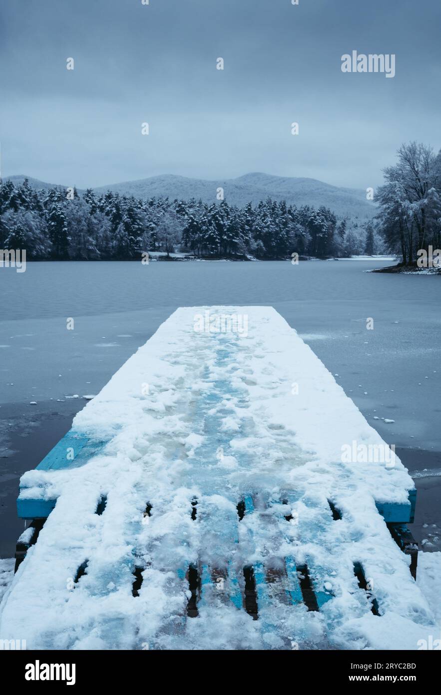 Dark landscape vertical photo of mole (pier) covered of snow with ...
