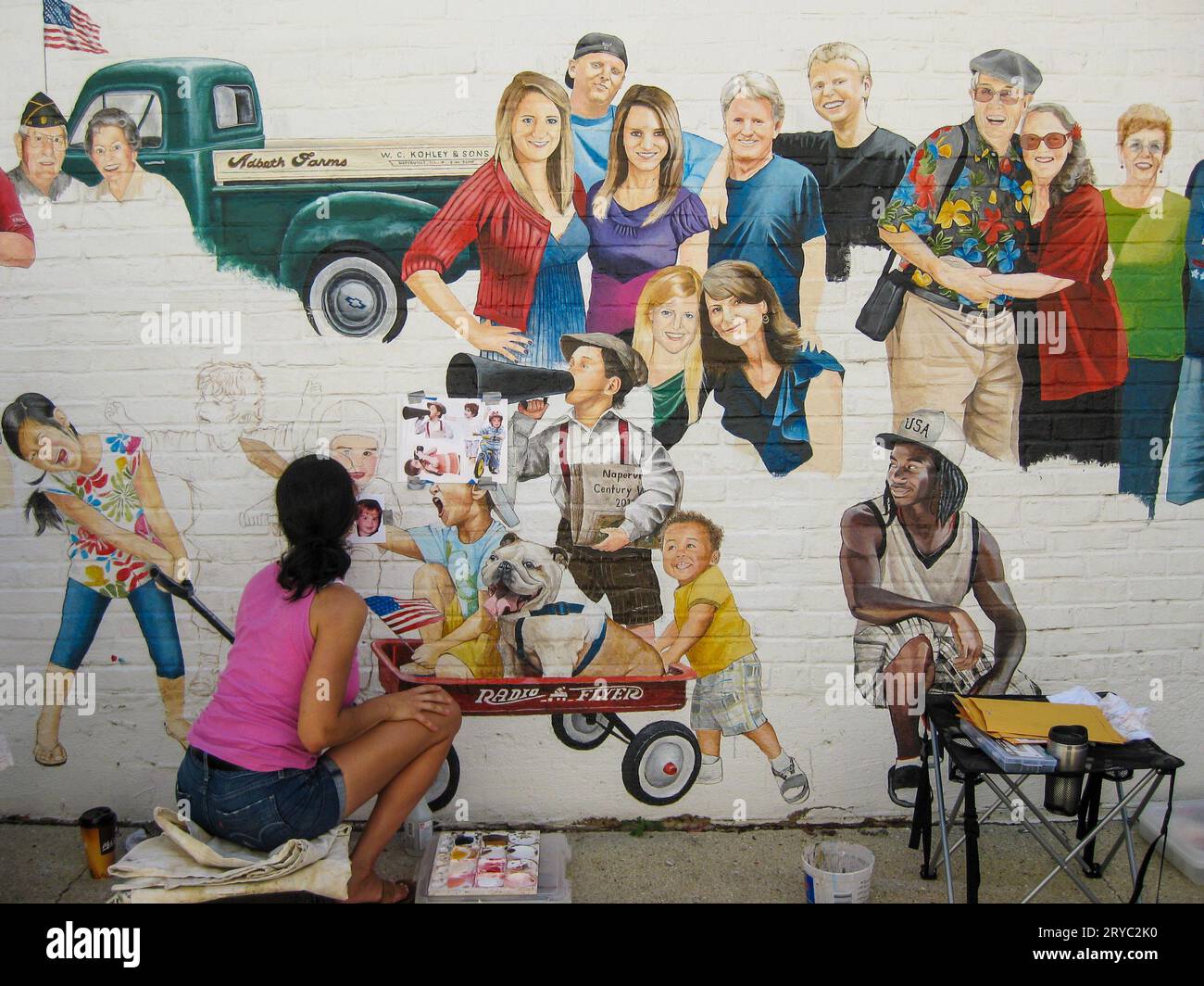 A woman is painting outdoor public mural Stock Photo - Alamy