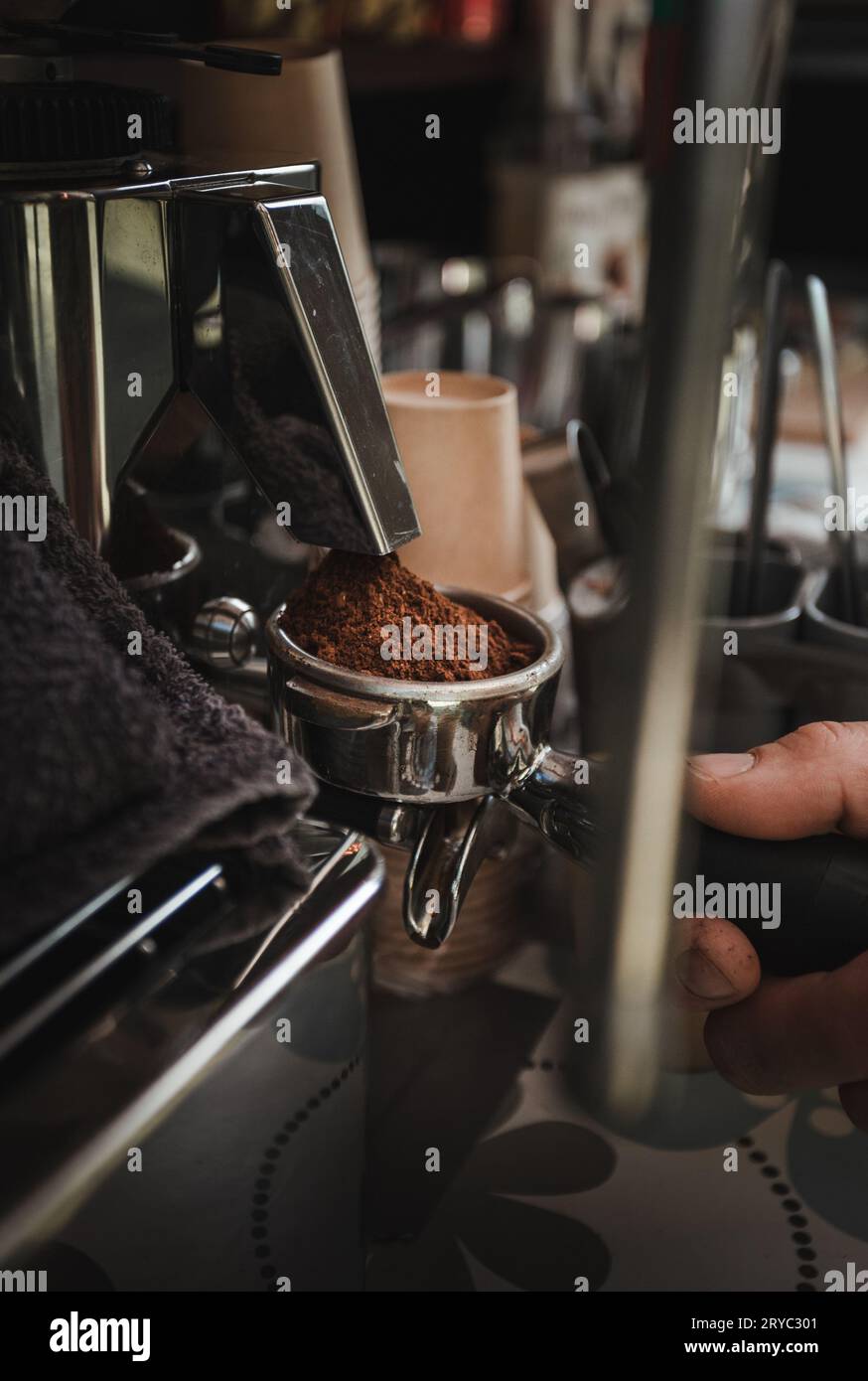 Barista preparing coffee in coffee machine with equipment - vertical ...