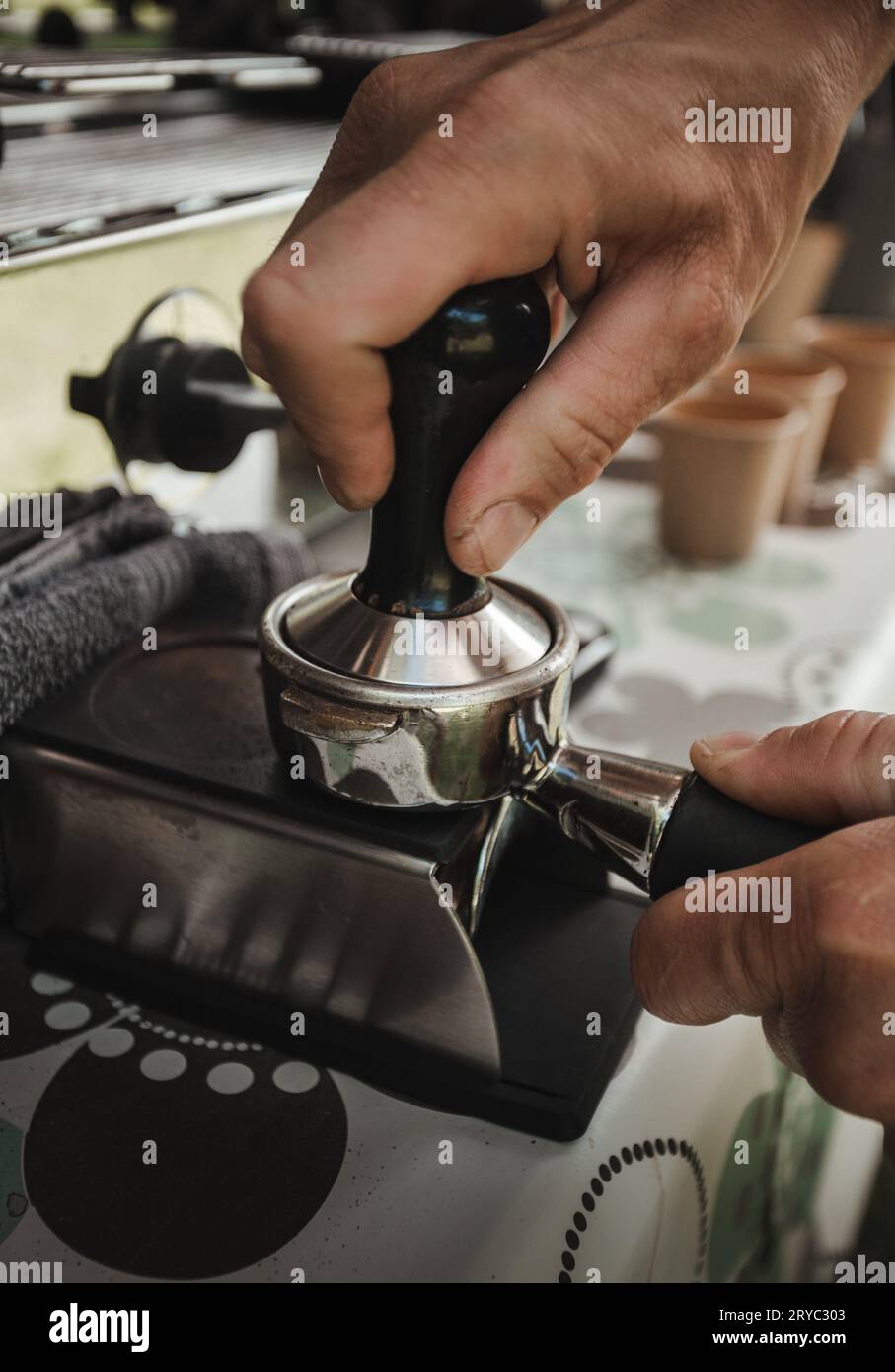 Barista preparing coffee in coffee machine with equipment - vertical ...