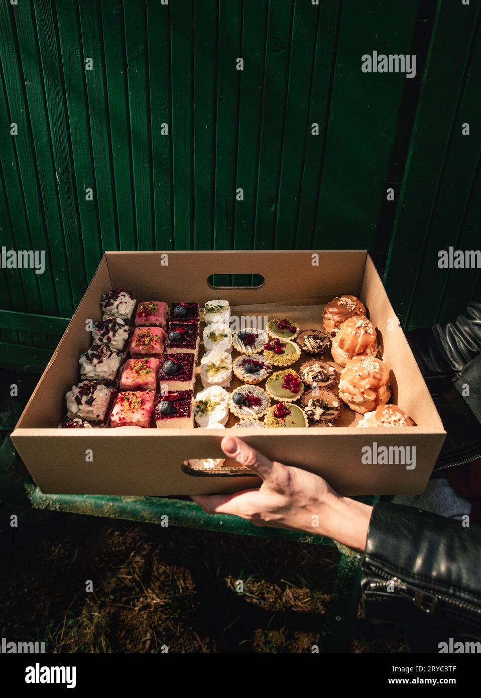 Close up photo of paper box full of cakes and pies (punch cake, mini ...