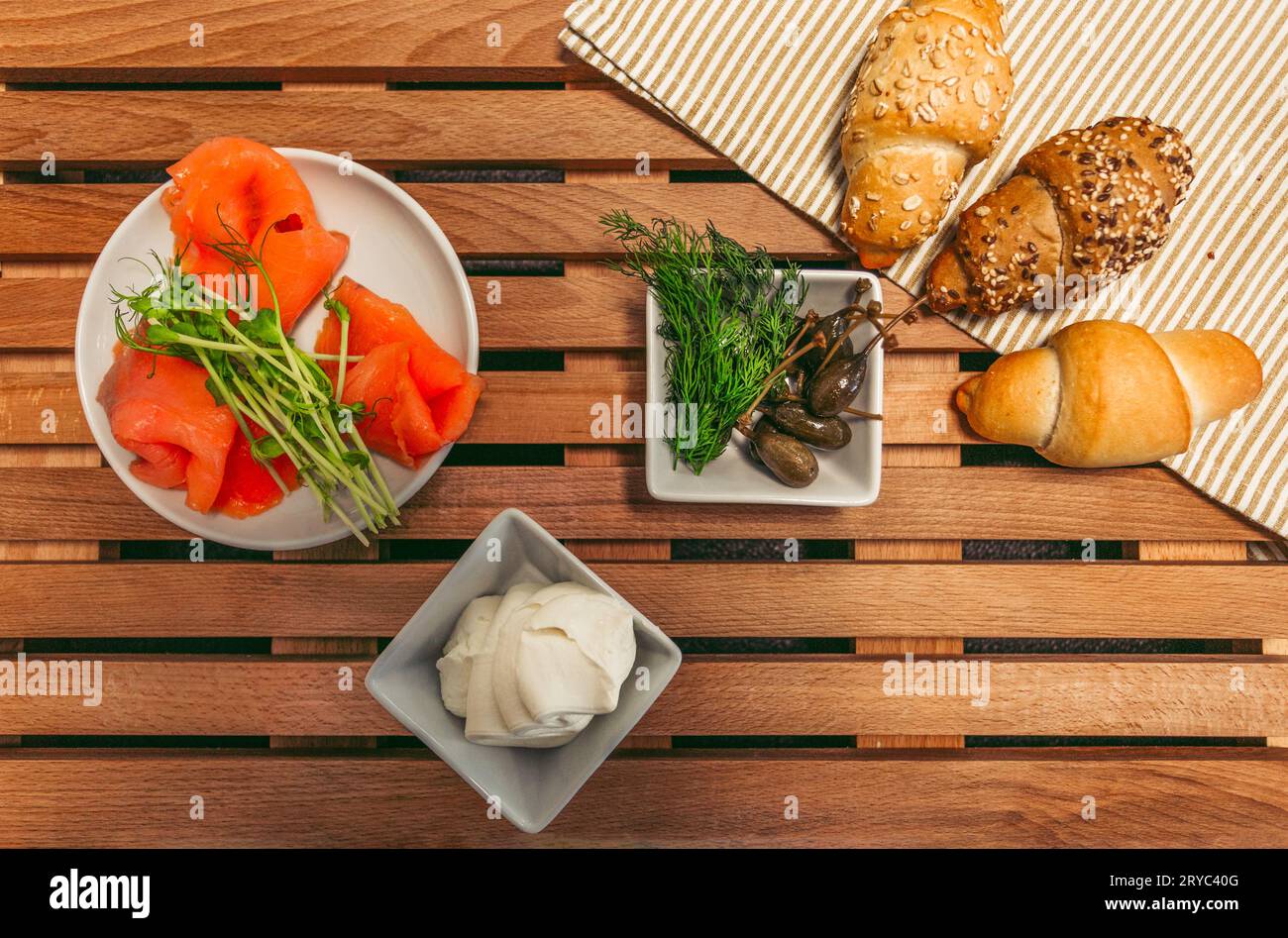 Lox, croissants, cream, capers and other ingredients prepared to ...