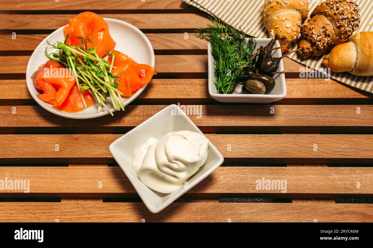 Lox, croissants, cream, capers and other ingredients prepared to ...
