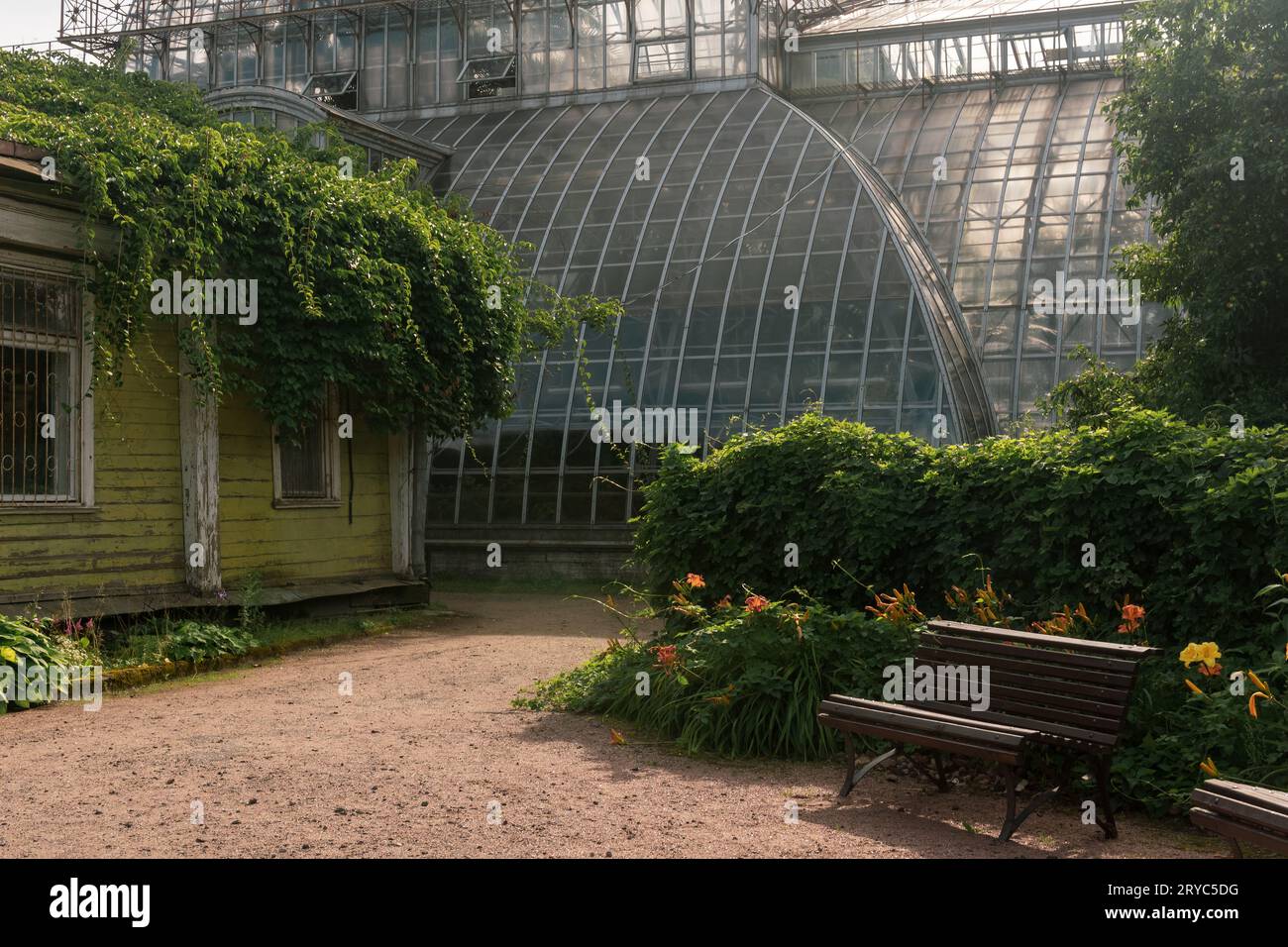 corner of an old botanical garden with a huge vintage greenhouse in the ...