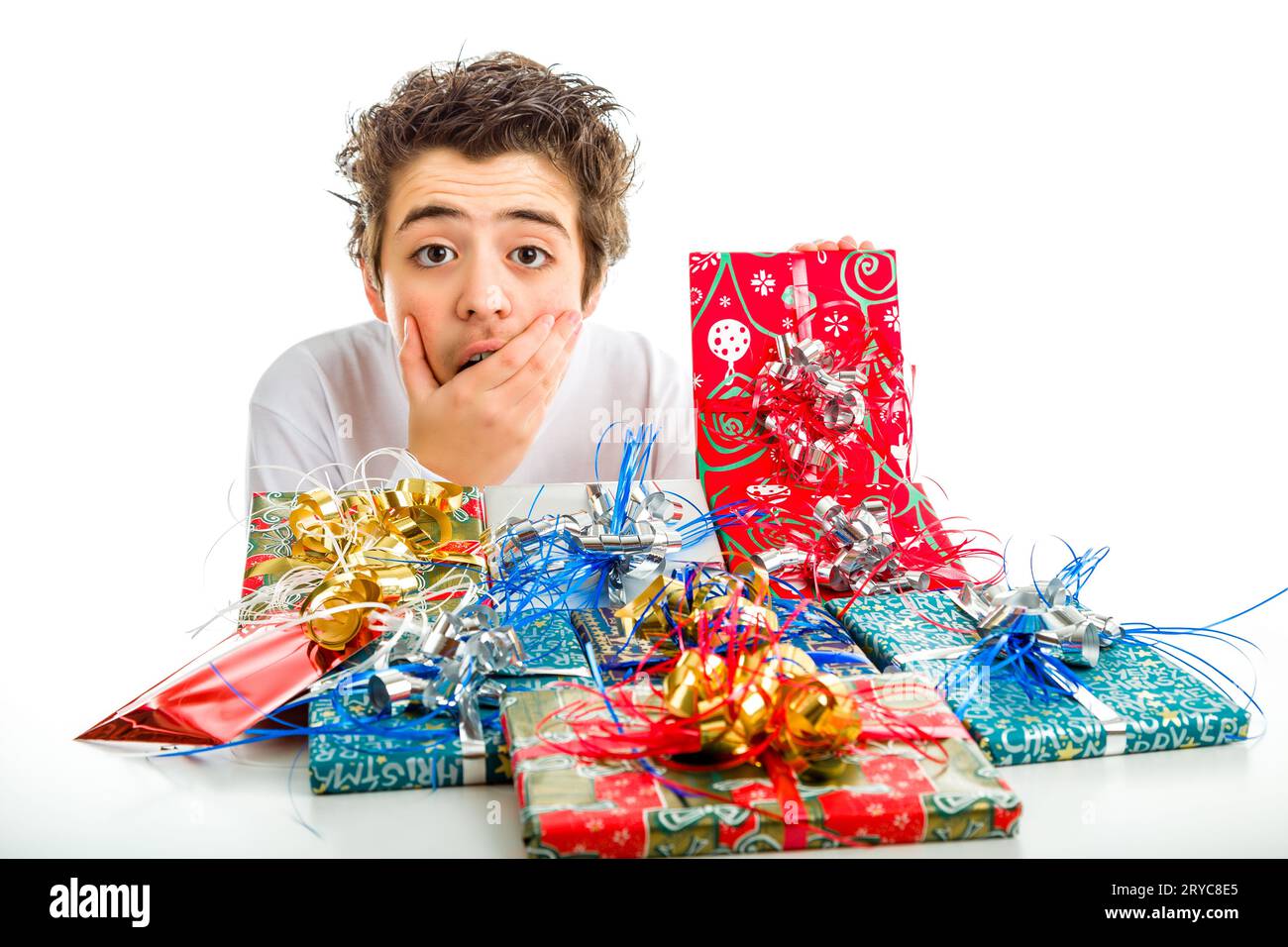 Amazed Boy holds his chin while receiving Christmas gifts Stock Photo ...