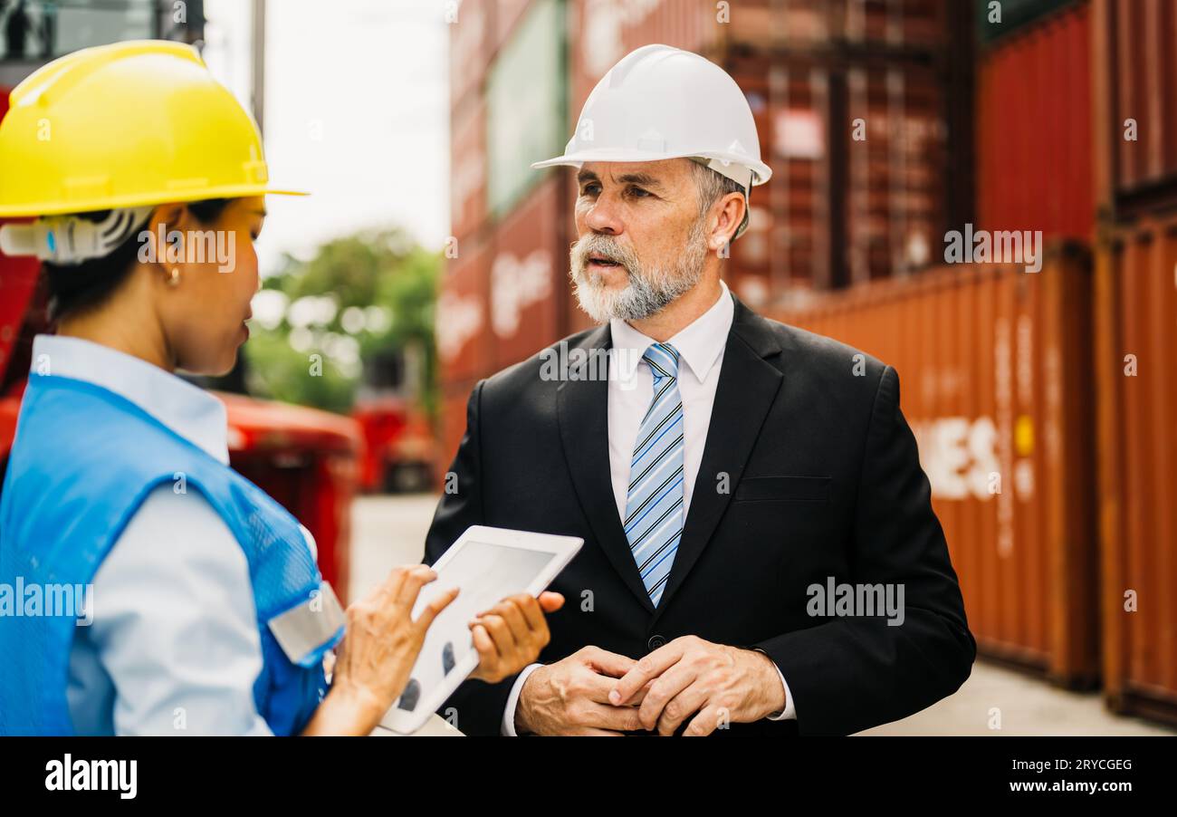 Businessman in black suit holding tablet checking goods at cargo ...