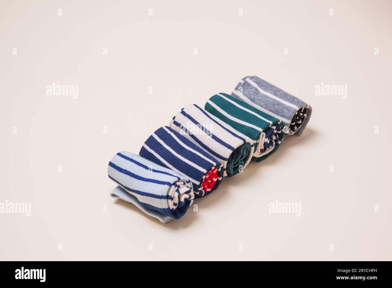 Multi colored socks are lined up isolated on beige background ...