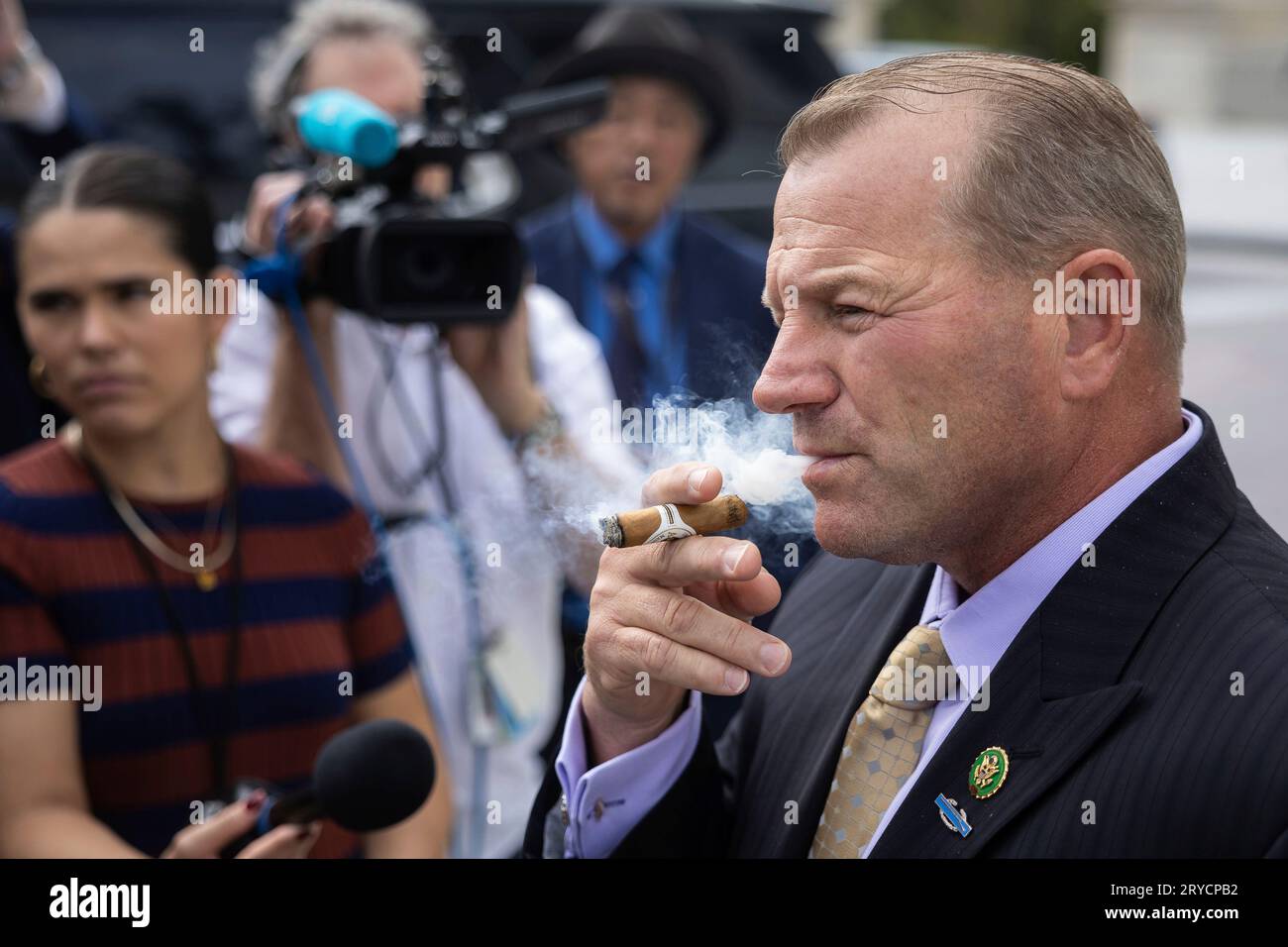 Rep. Troy Nehls (R-Texas) smokes a cigar while speaking with reporters ...
