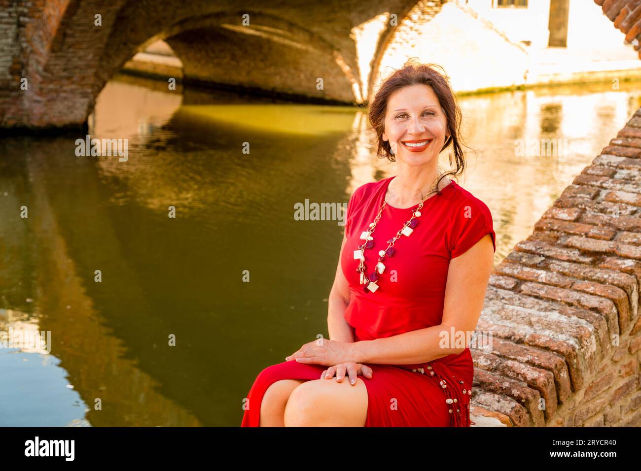 Classy woman sitting on bridge Stock Photo - Alamy