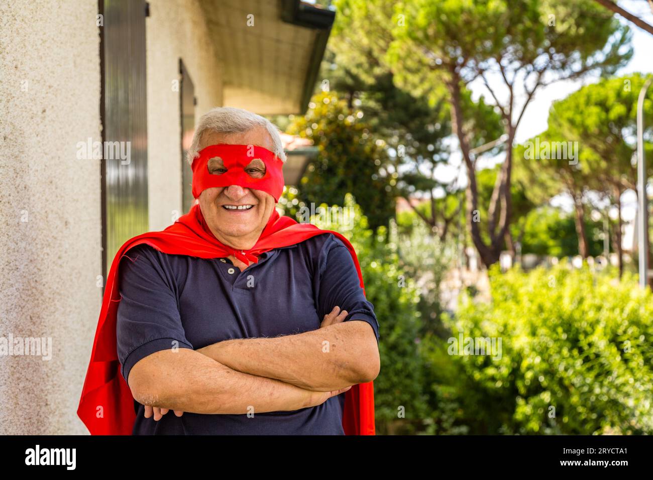 Senior dressed as superhero with red cape and mask Stock Photo - Alamy