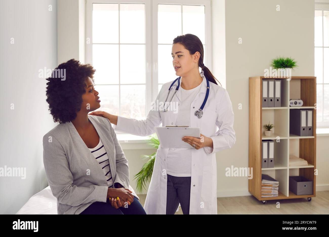 Smiling friendly doctor giving consultation a woman during medical ...