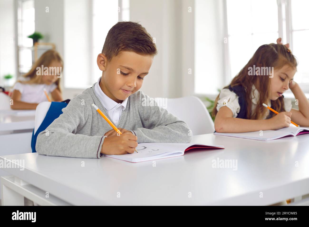 Focused boy draws in workbook during studies completes assignment from ...