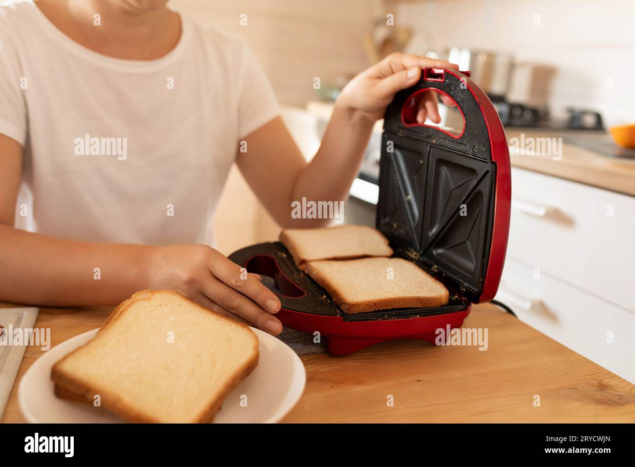 the woman put slices of bread in the toaster Stock Photo - Alamy