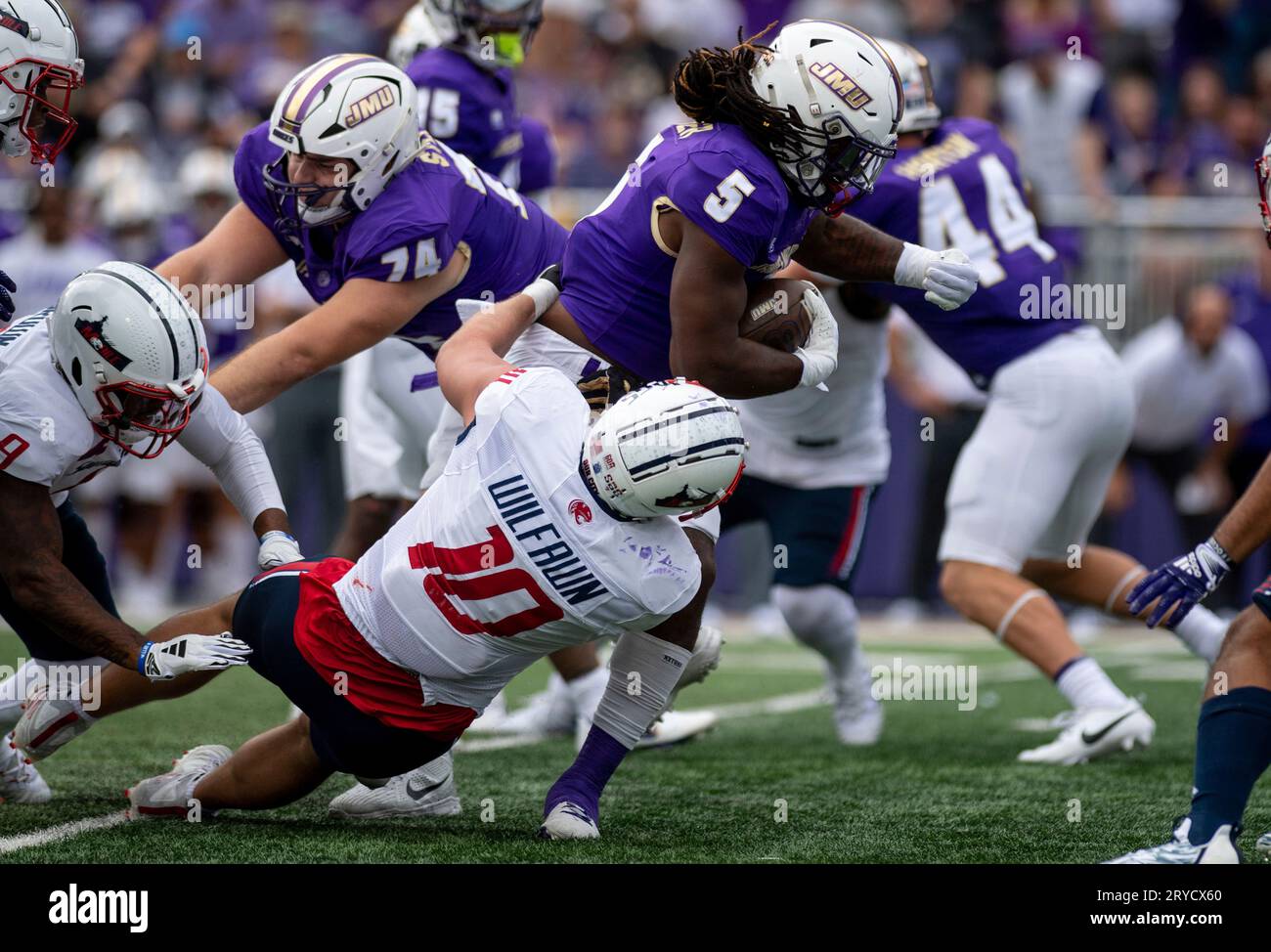 James Madison running back Latrele Palmer (5) fights for extra yards as ...