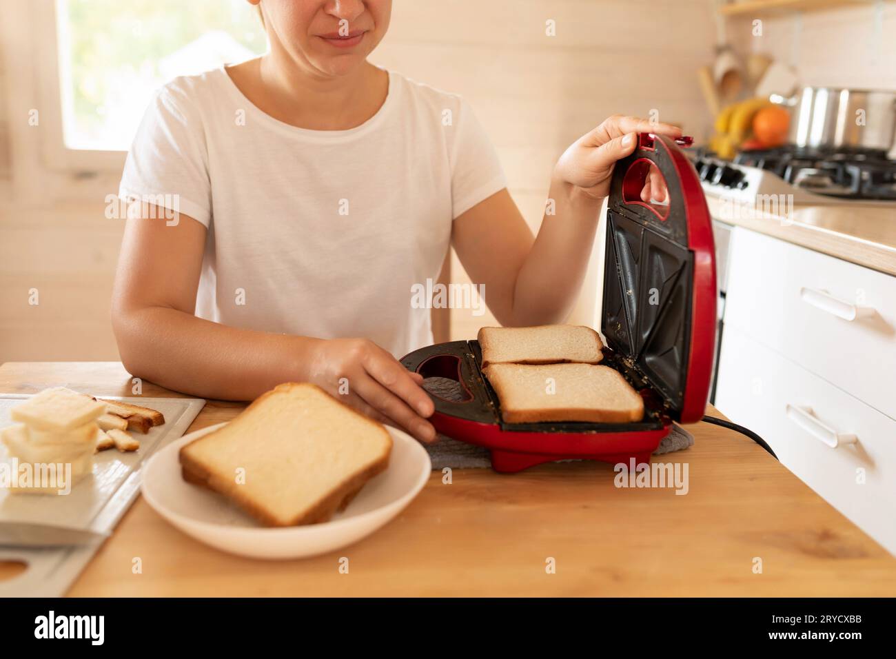 a woman is going to make toast in the toaster oven in the kitchen Stock ...