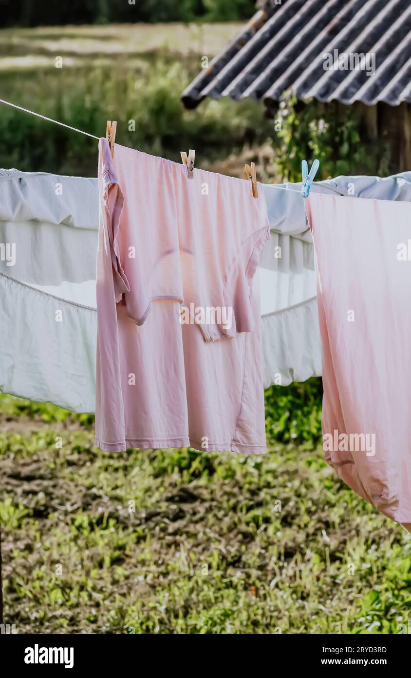 Washed colorful cotton laundry hanging on the rope. Textile drying on ...