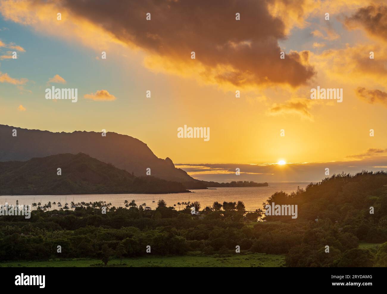 Sun slowly setting over the ocean of Hanalei Bay on the north coast of ...