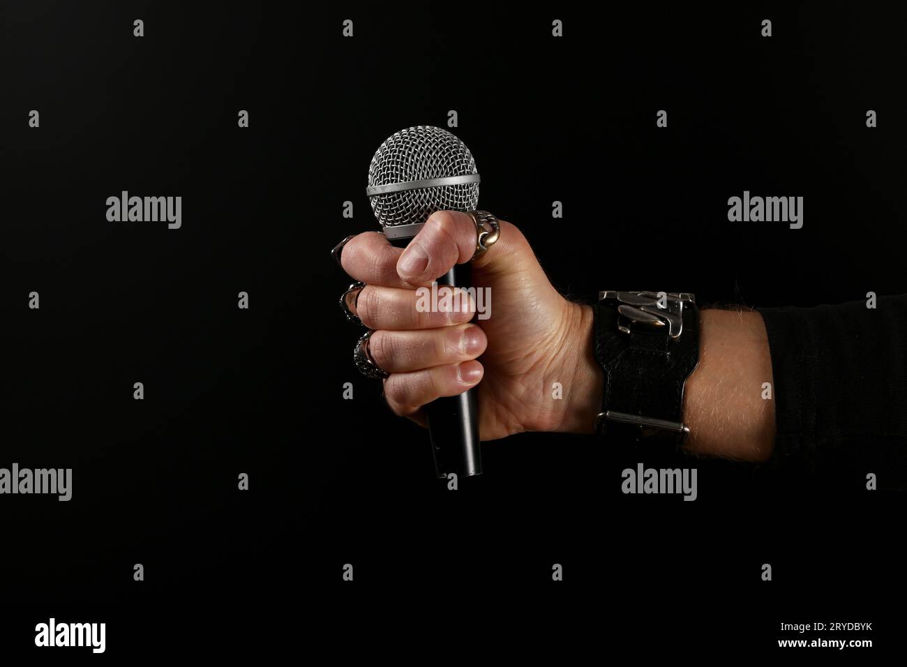 Man hand with microphone isolated on black Stock Photo - Alamy