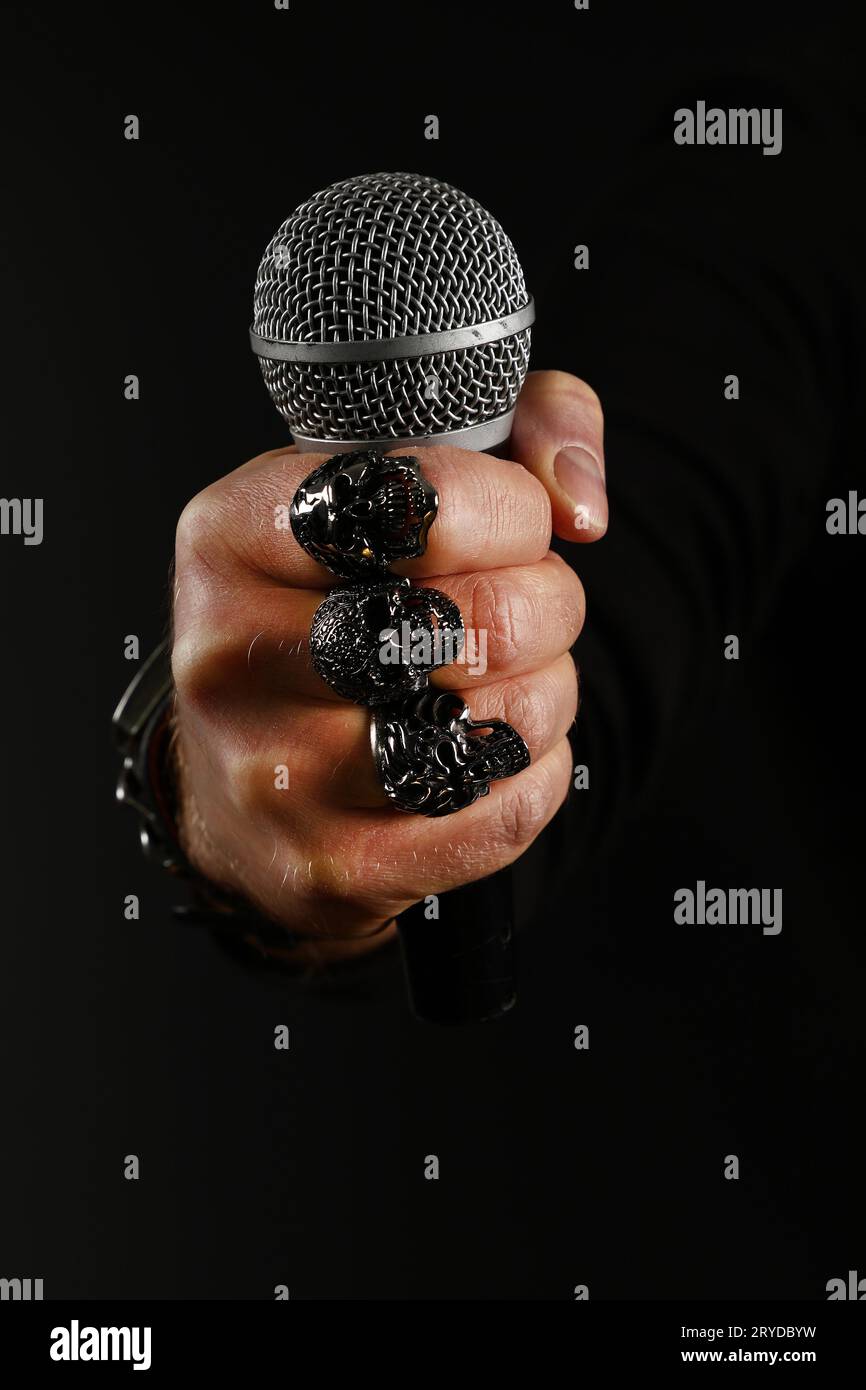 Man hand with microphone isolated on black Stock Photo - Alamy