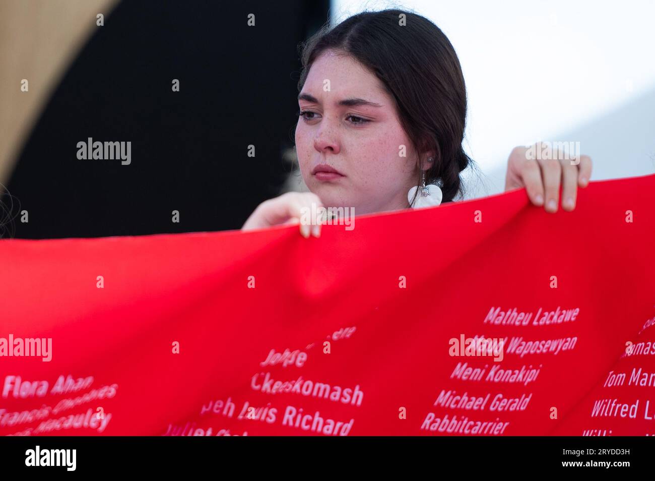 Ottawa, Canada. 30th Sep, 2023. A person helps carry the memorial cloth ...