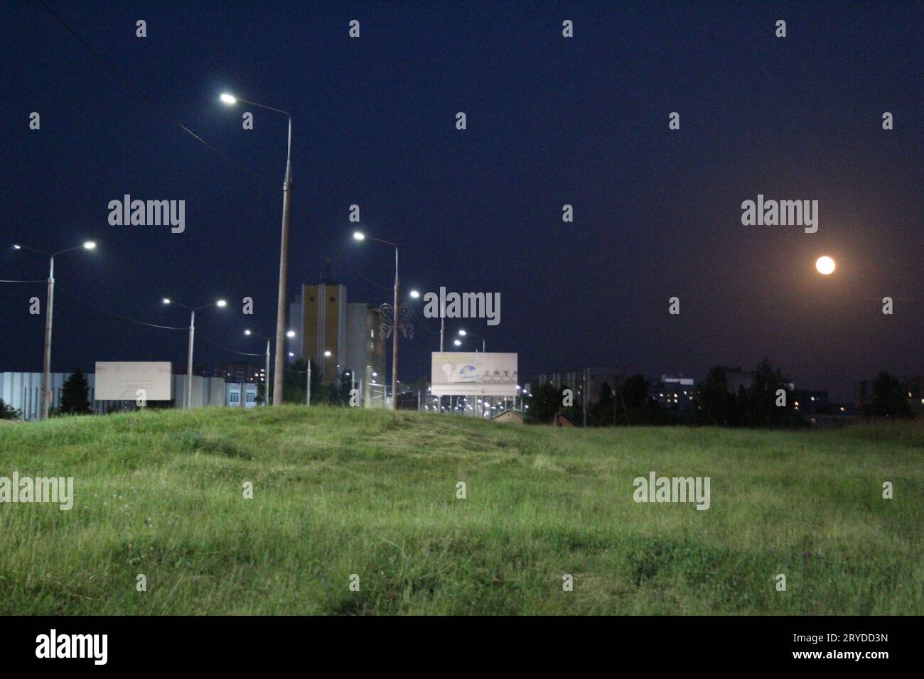 the moon on the outskirts of the city at night under the light of ...