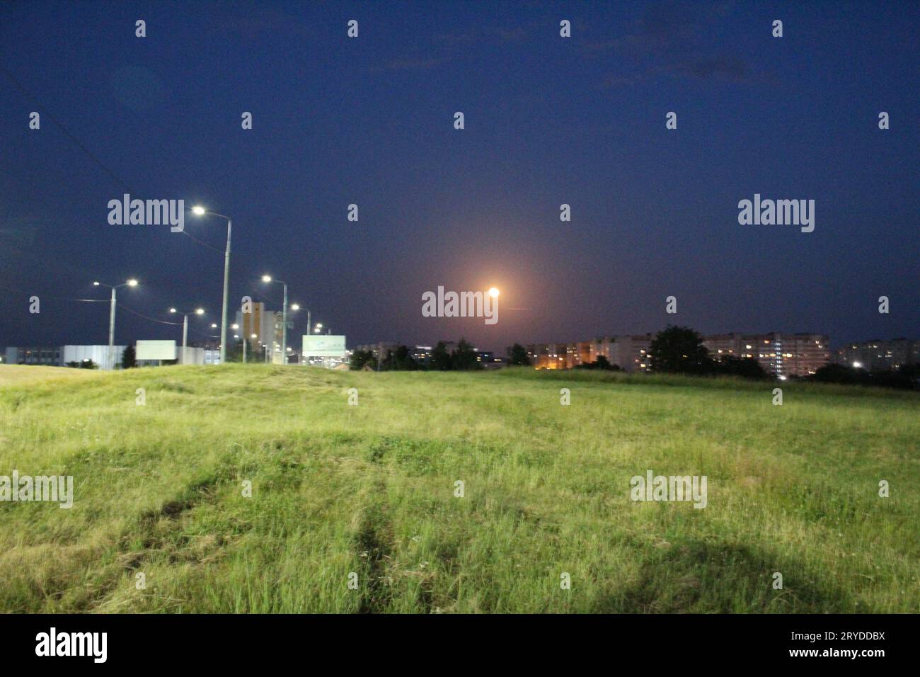 the moon on the outskirts of the city at night under the light of ...