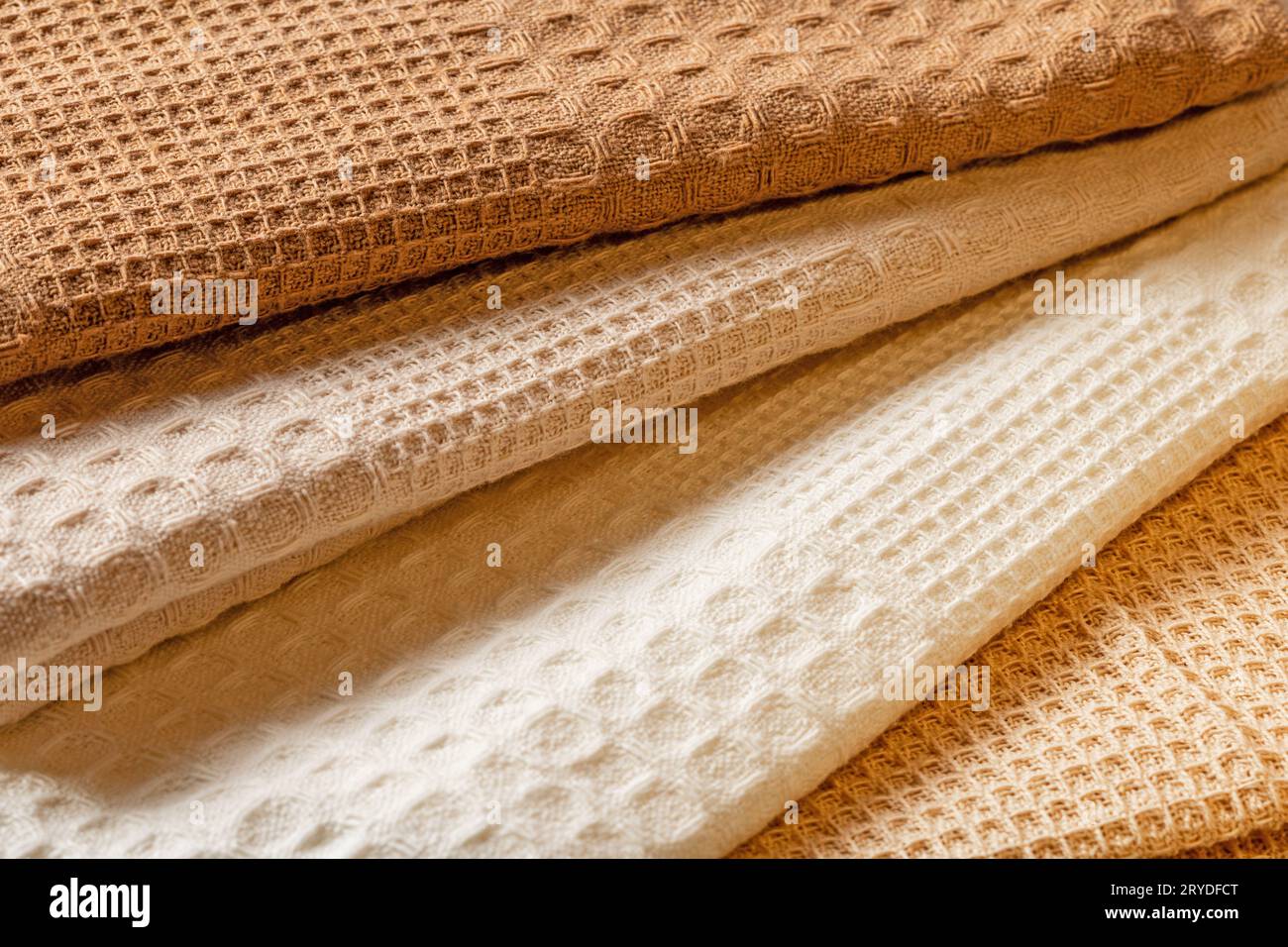 Stack of beige and cream colored waffle kitchen towels folded into ...