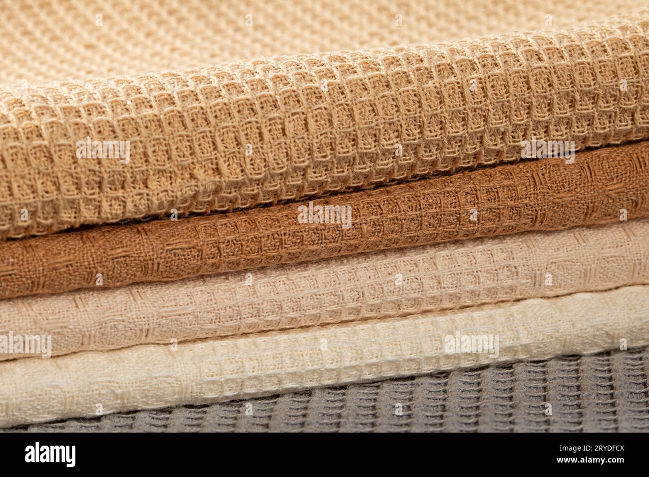 Stack of beige,gray and cream colored waffle kitchen towels folded into ...