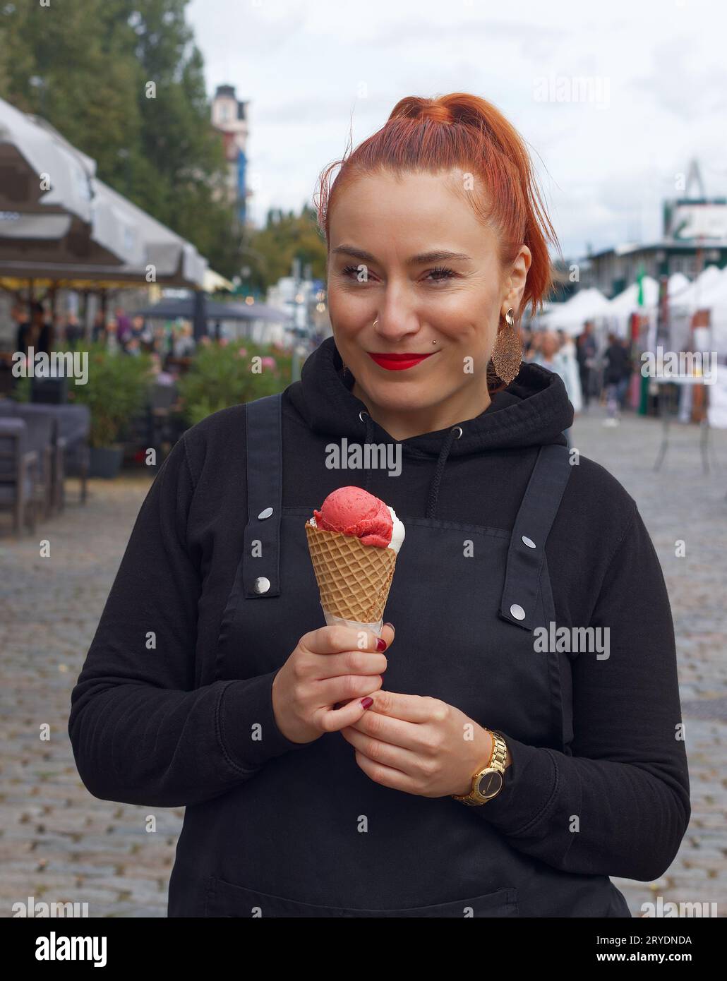 Pretty young smiling woman posing with an ice cream cone at the farmers ...