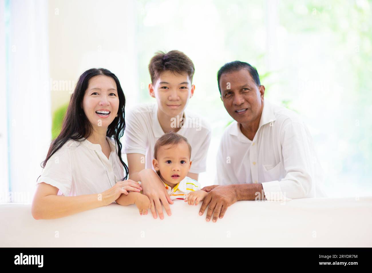 Happy Asian family with kids at home. Parents and children sitting on ...