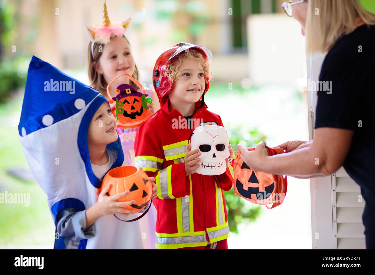 Kids trick or treat in Halloween costume. Children in colorful dress up ...