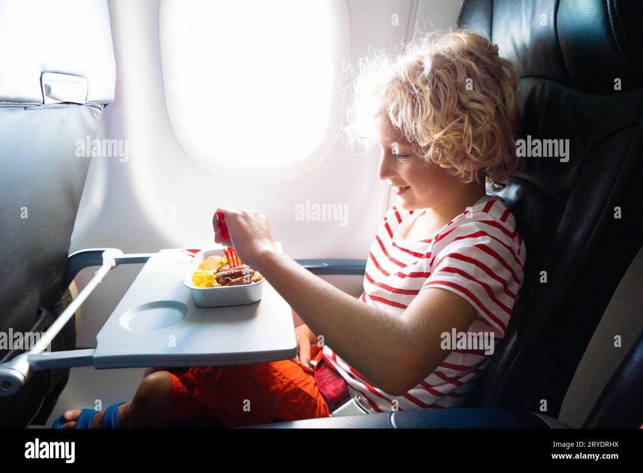 Child in airplane window seat. Kids flight meal. Children fly. Special ...