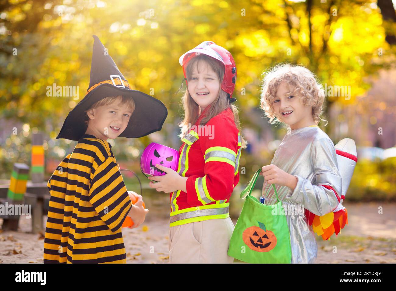 Kids trick or treat in Halloween costume. Children in colorful dress up ...