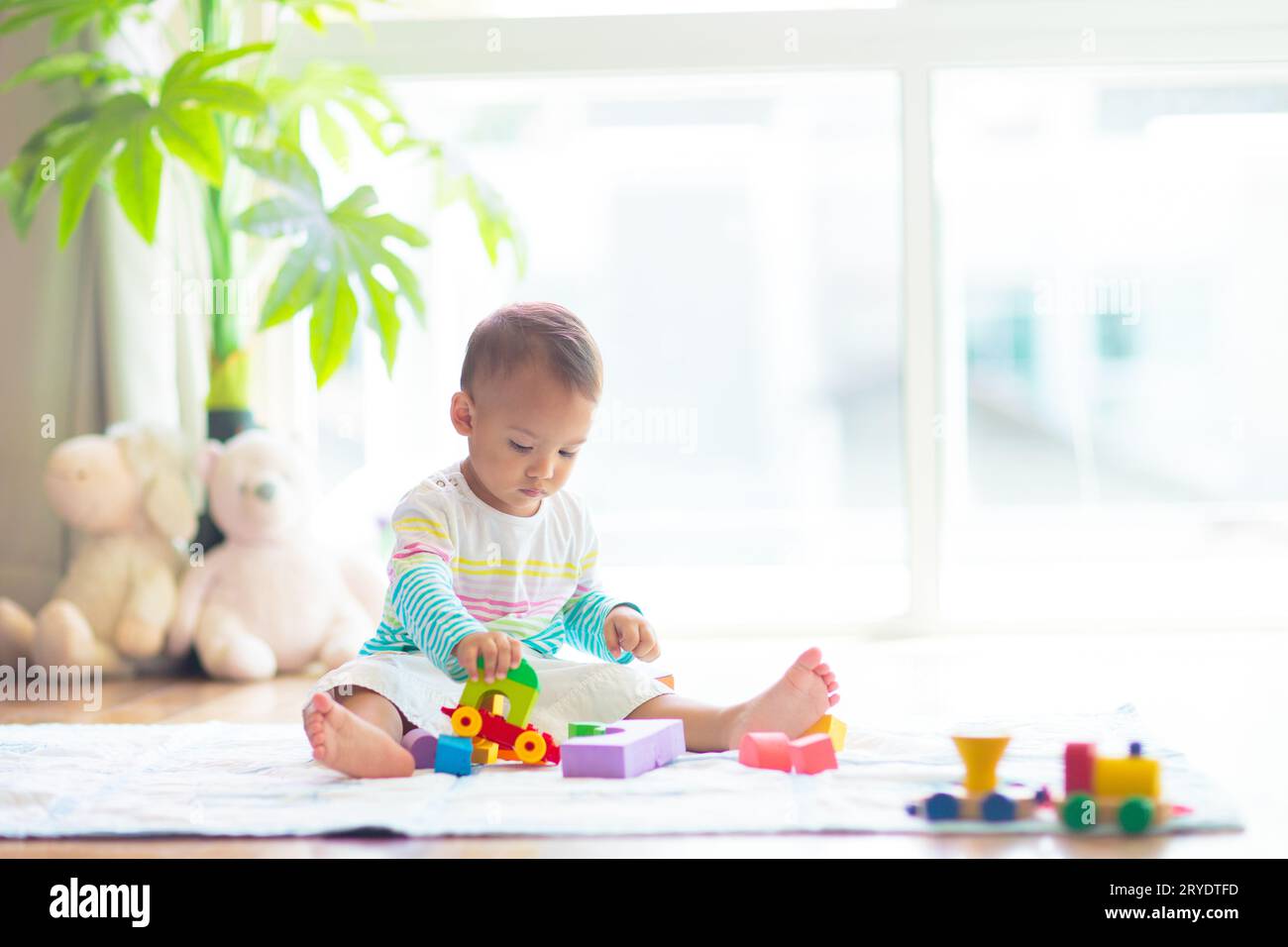 Adorable Asian baby boy learning to crawl and playing with colorful ...