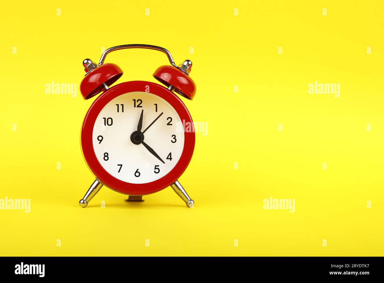 Close up one red alarm clock over yellow background Stock Photo - Alamy