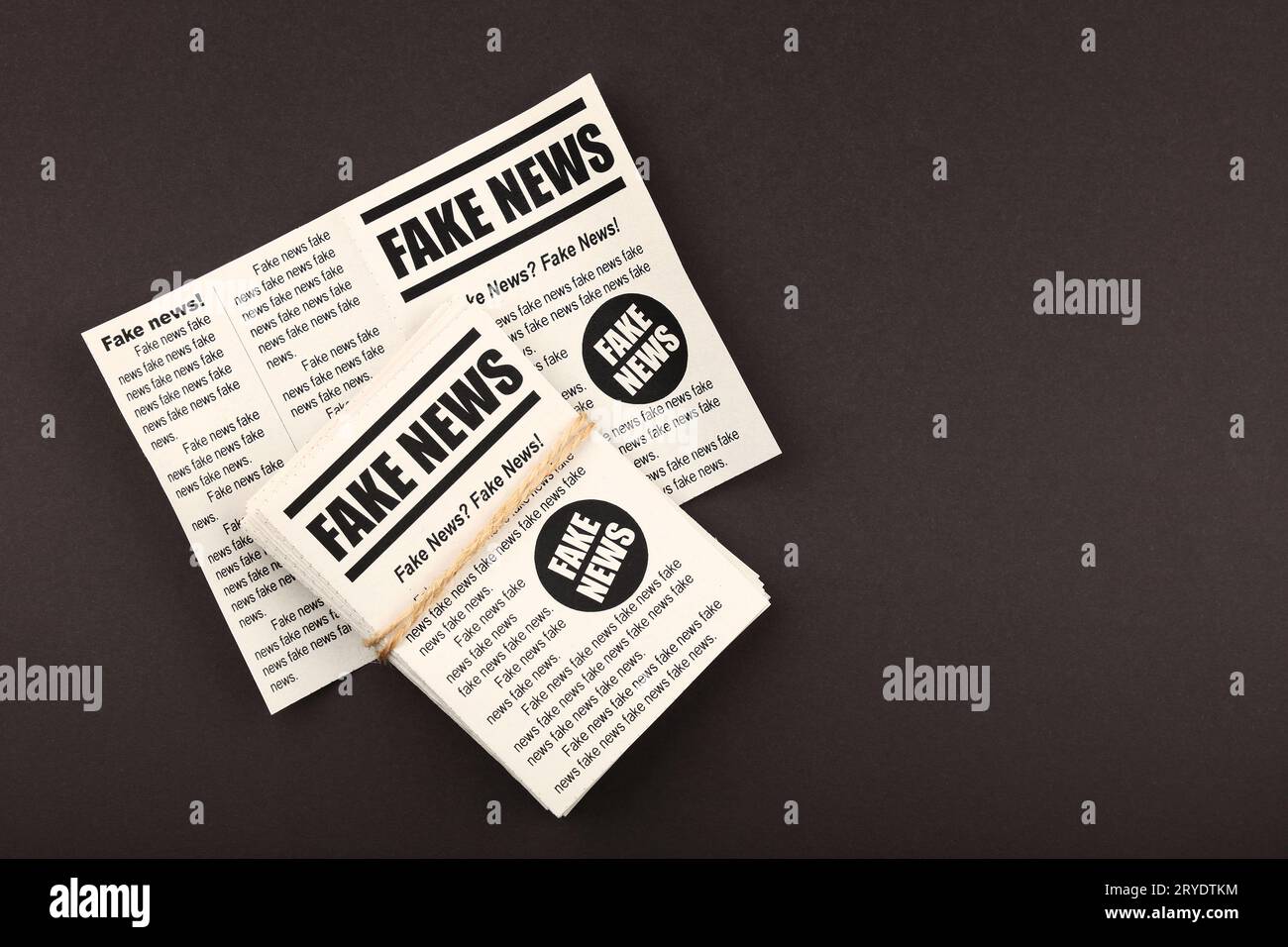 Stack of FAKE NEWS newspapers over black Stock Photo - Alamy